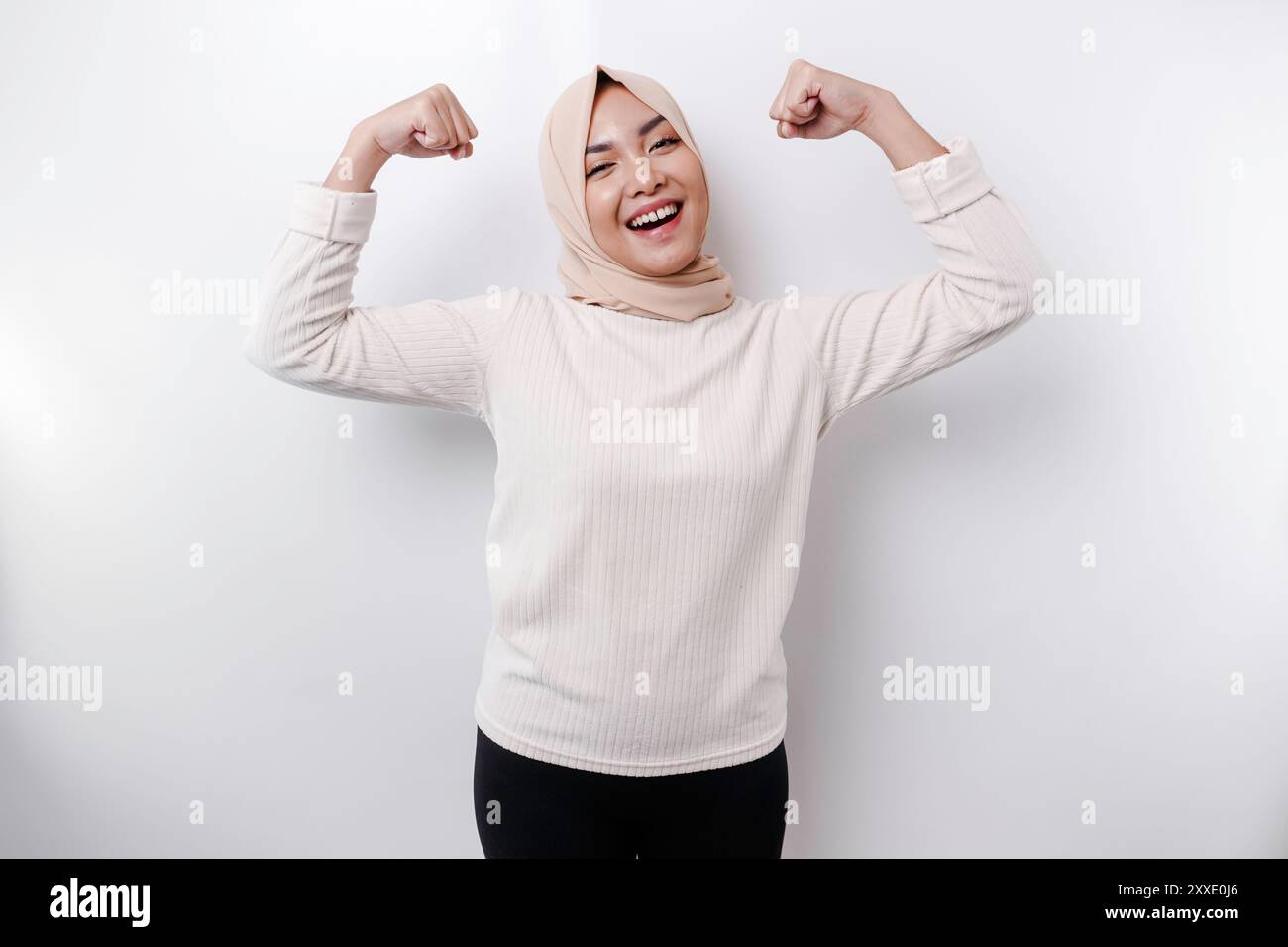 Excited Asian Muslim woman wearing a headscarf showing strong gesture ...