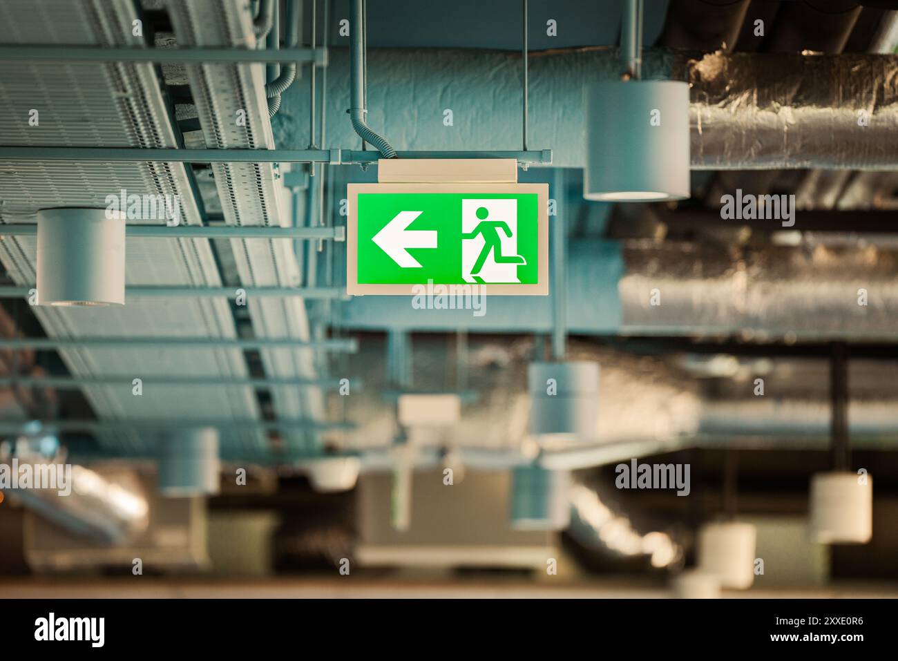 Emergency exit sign. Office spaces. Industrial ceiling Stock Photo - Alamy