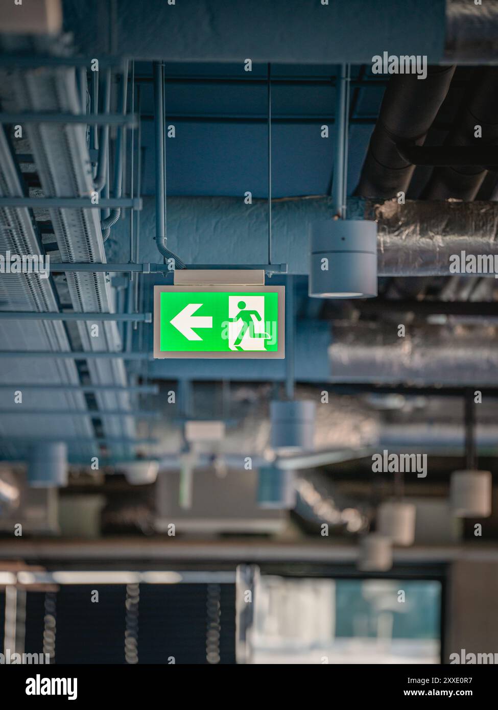 Emergency exit sign. Office spaces. Industrial ceiling Stock Photo - Alamy