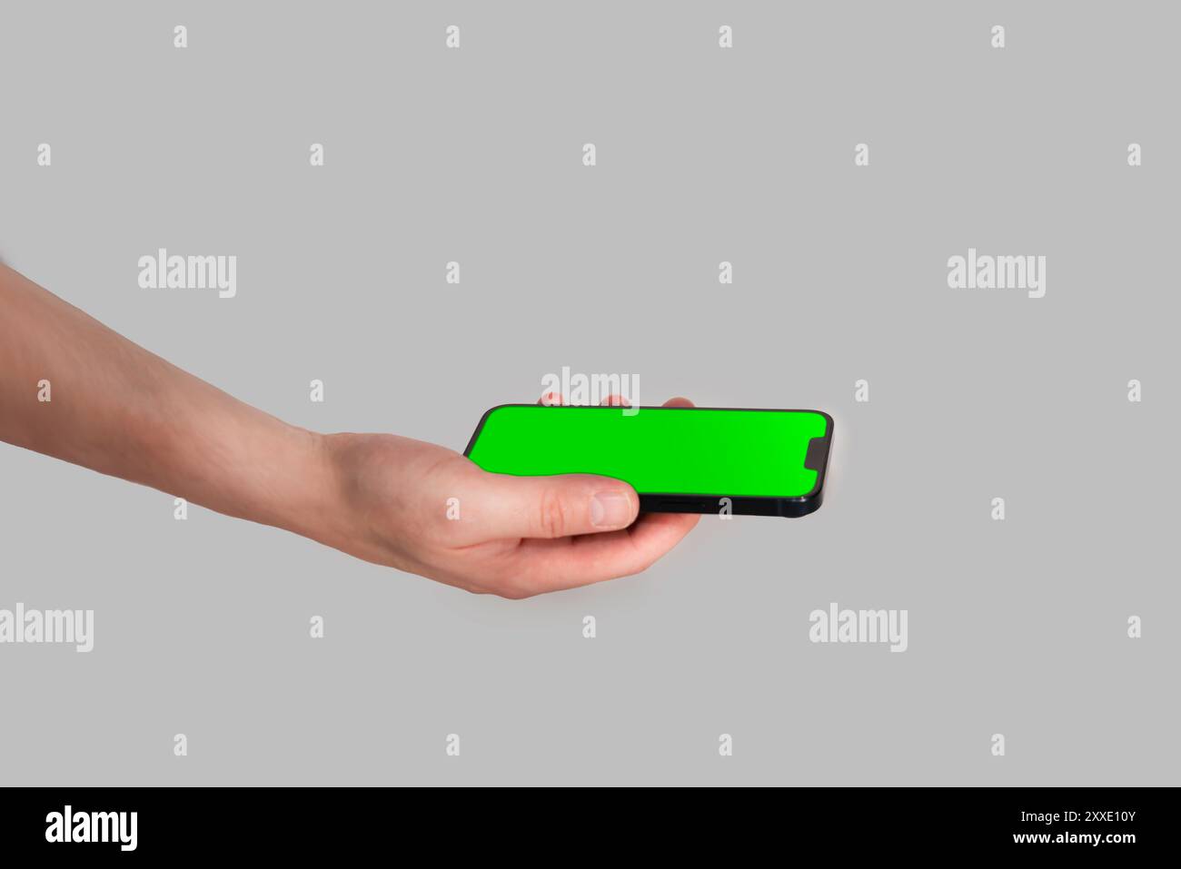 Hand holding smartphone. Clean empty touch green screen. White ...