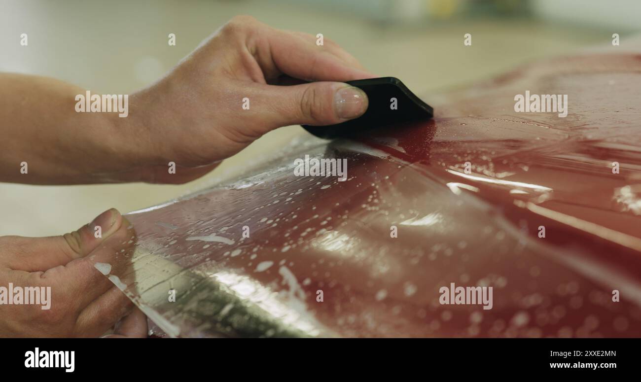 professional applying protective film to the red car, wide photo Stock ...