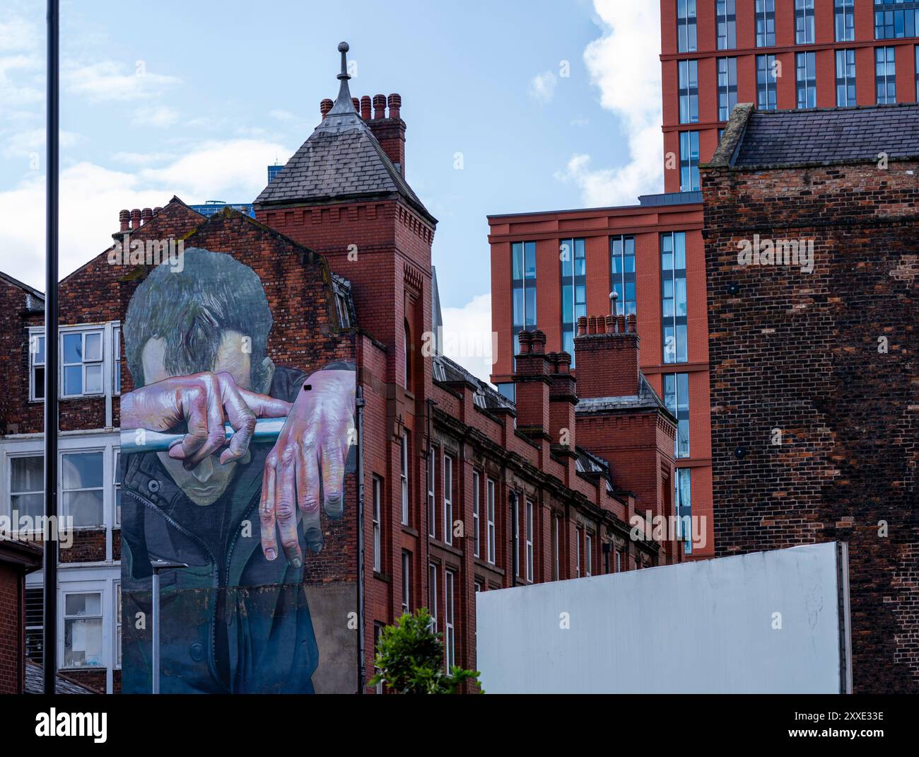 A large mural on a brick building in Manchester, UK. The mural depicts ...