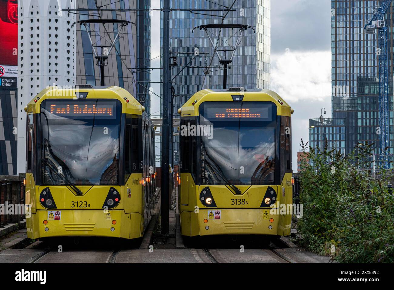 Tow yellow trams in Manchester going past each other on different ...