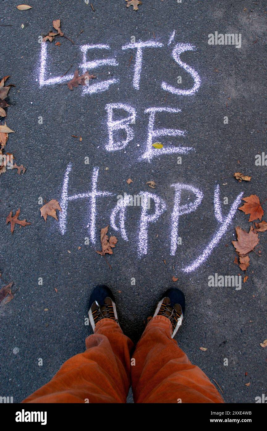 The words " Let's be happy" written on the pavement on one of the paths ...
