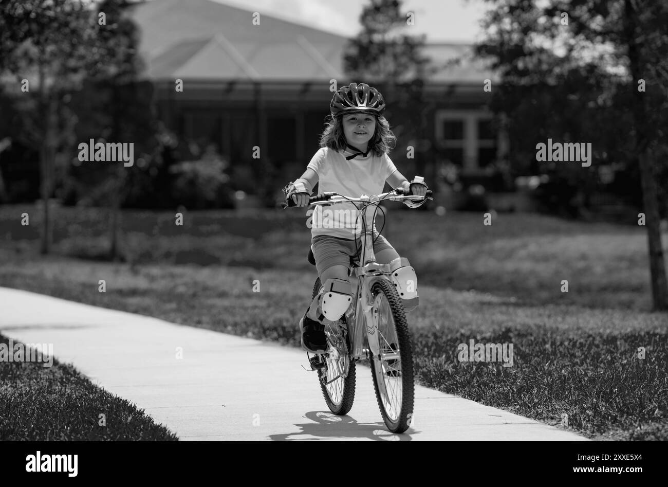 Kid riding bike in a helmet. Child with a childs bike and in protective ...