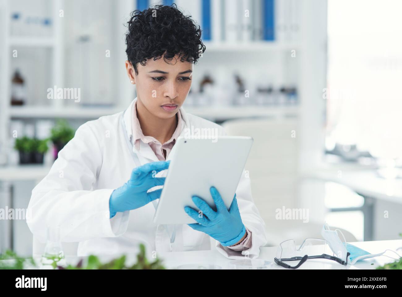 Woman, scientist and tablet with writing in lab for plant research, cell structure and ...
