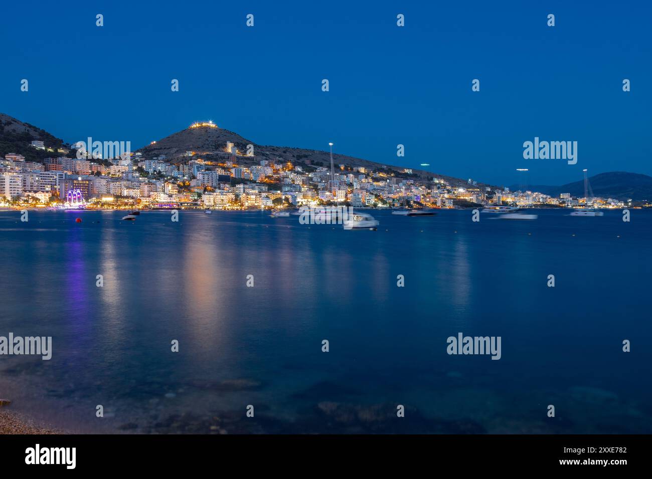 Sunset over the boulevard of Sarande with the blue hour. People on ...