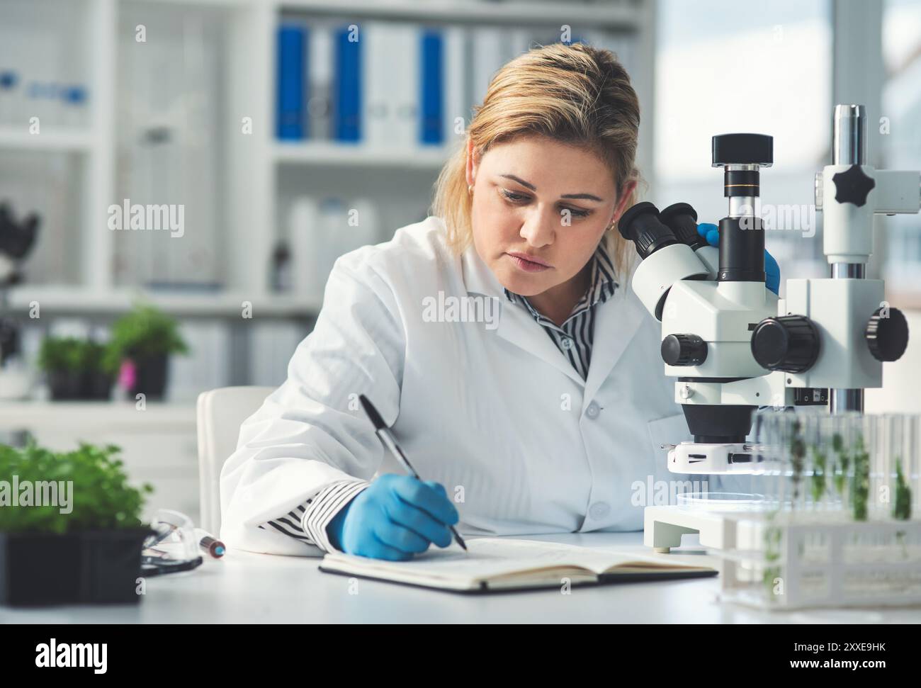 Woman, scientist and microscope with writing in lab for plant experiment, cell structure and ...