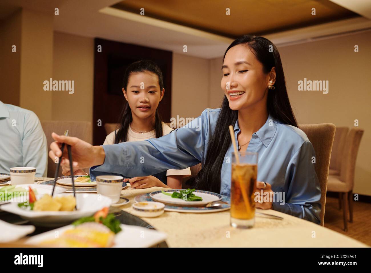 Woman Having Dinner With Her Family Stock Photo - Alamy