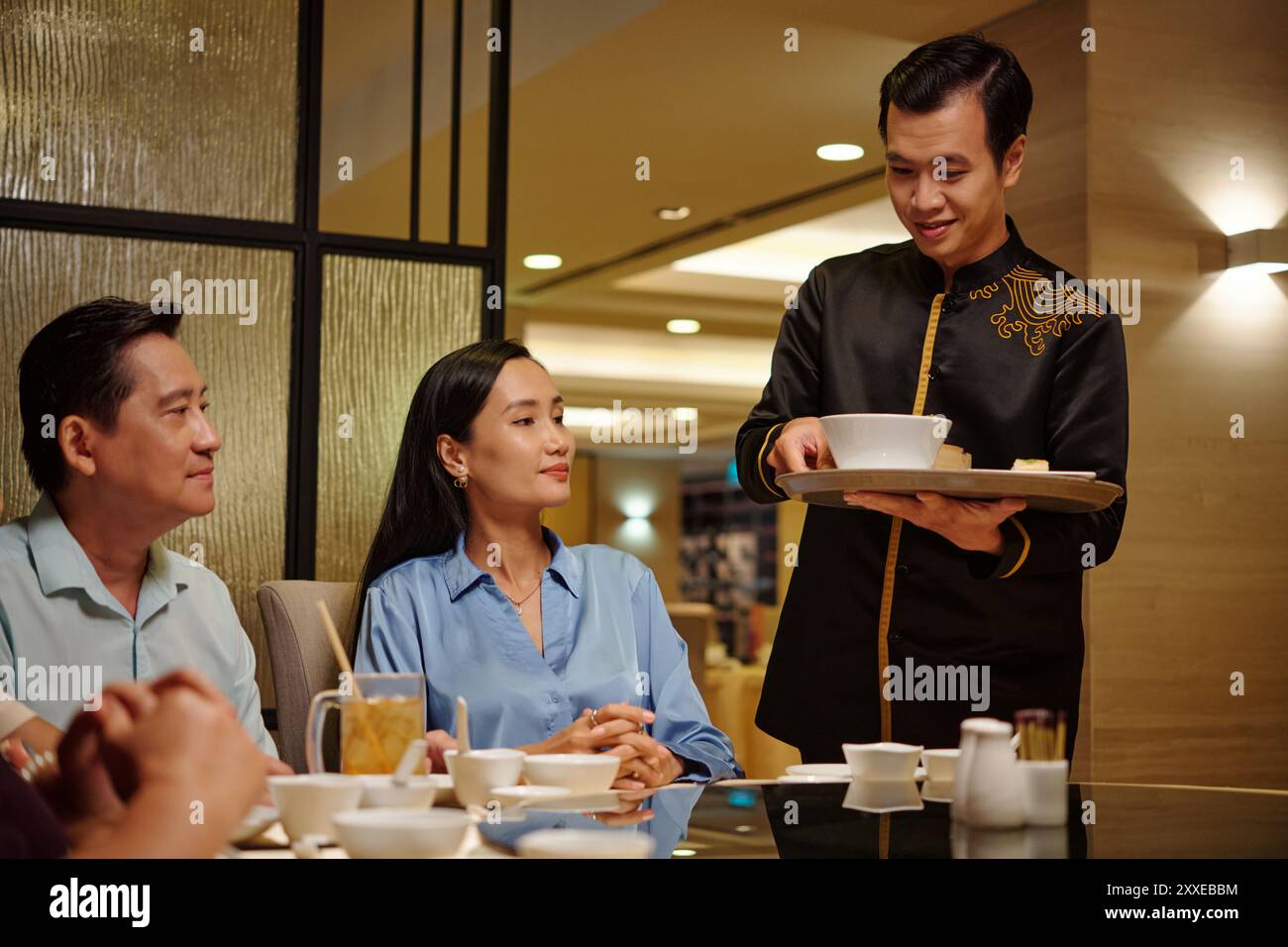 Waiter Serving Family In The Restaurant Stock Photo - Alamy