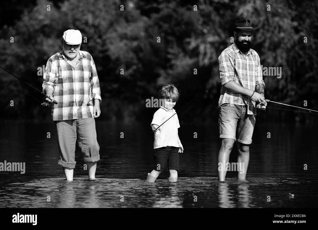 Boy with father and grandfather fly fishing outdoor over river ...