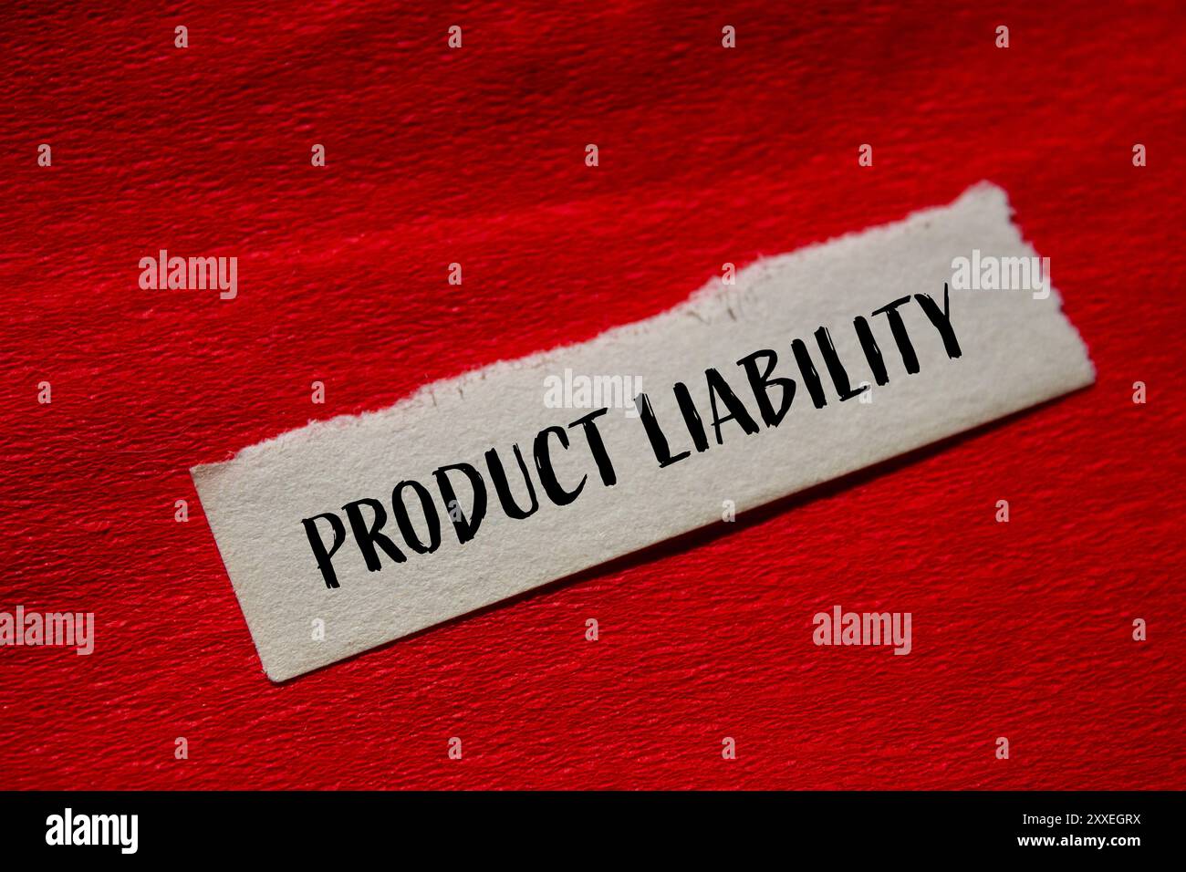 Product liability message written on torn paper with red background ...