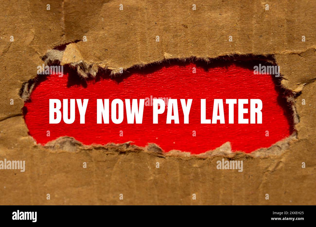 Buy now pay later message written on torn cardboard paper with red ...