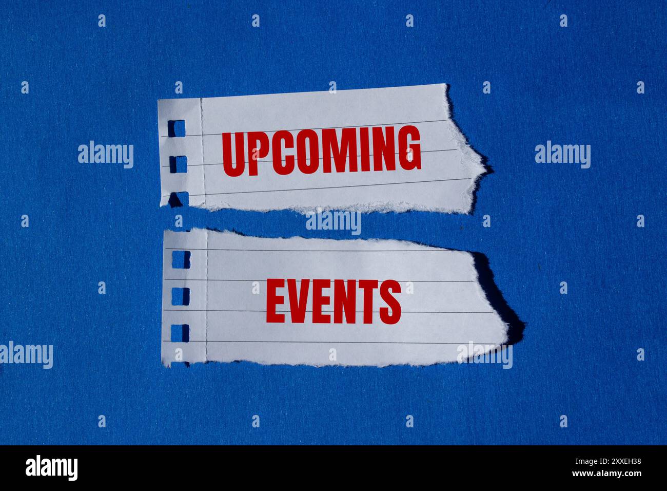 Upcoming events message written on ripped torn paper pieces with blue background. Conceptual ...