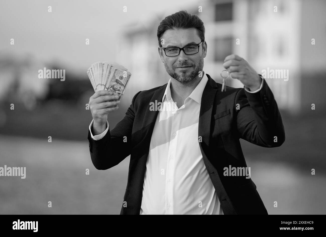 New home owner. Successful real estate agent in suit with money dollars ...
