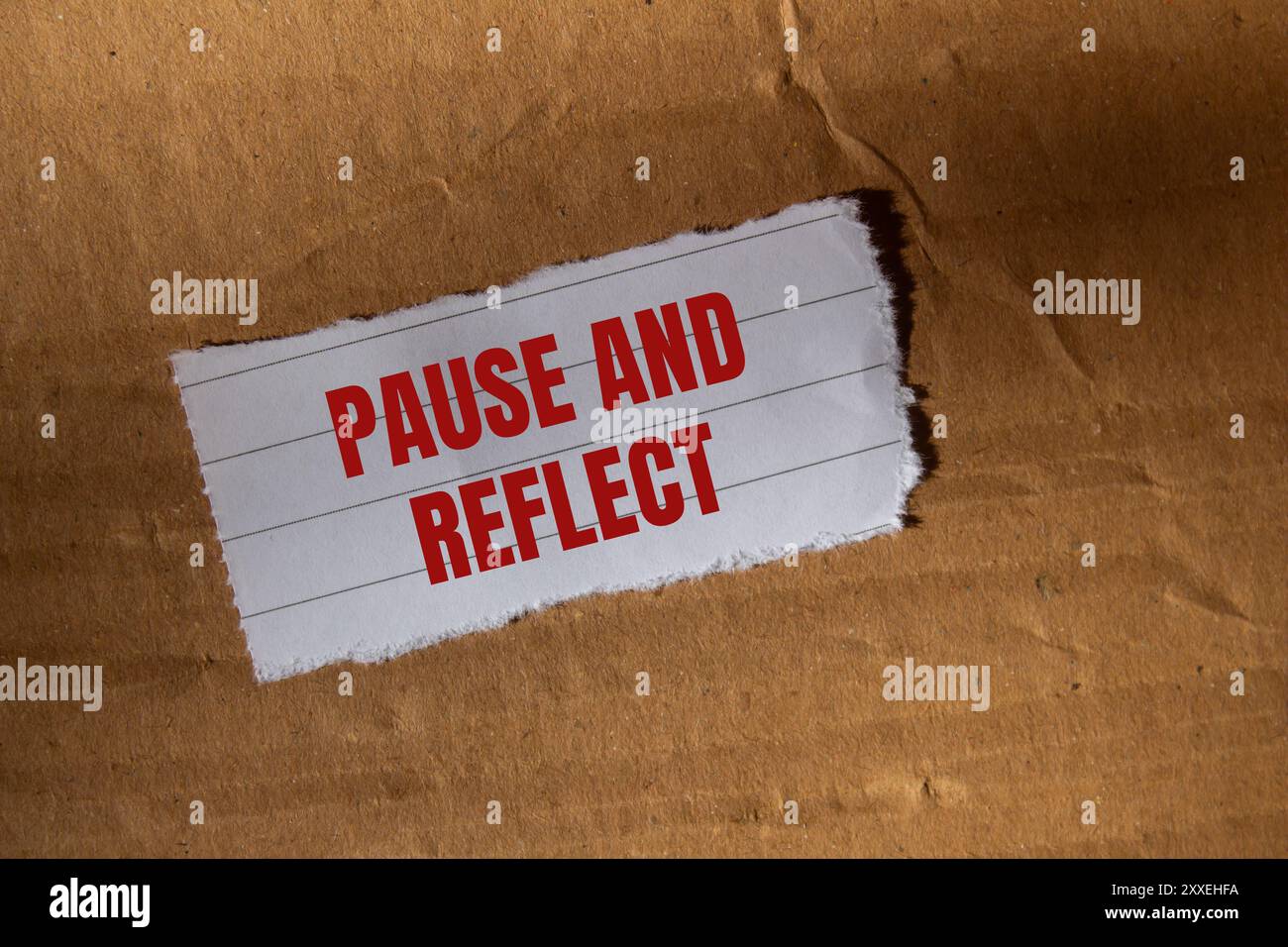 Pause and reflect message written on ripped torn white paper piece with ...
