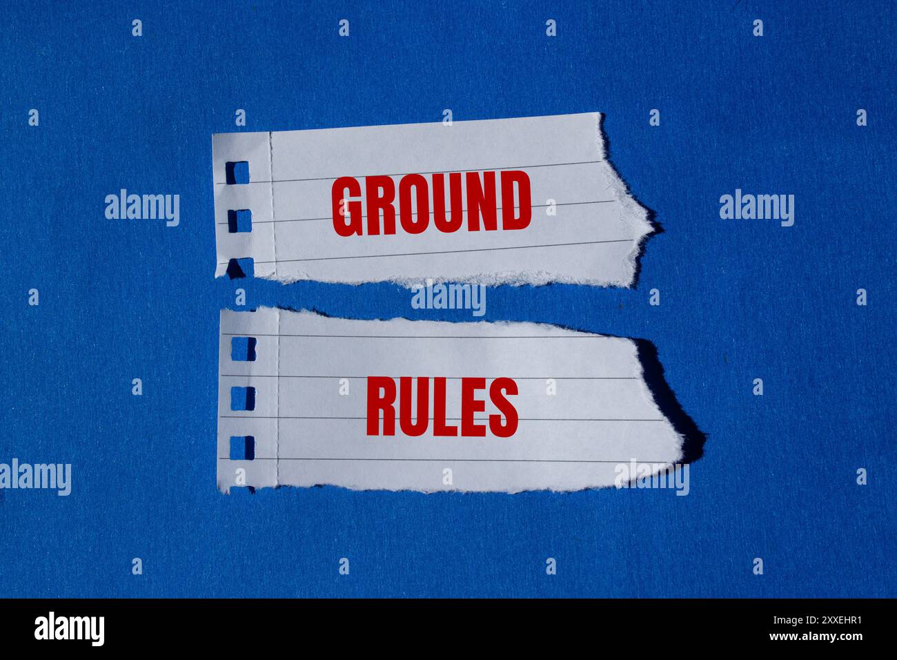 Ground rules message written on ripped torn paper pieces with blue ...