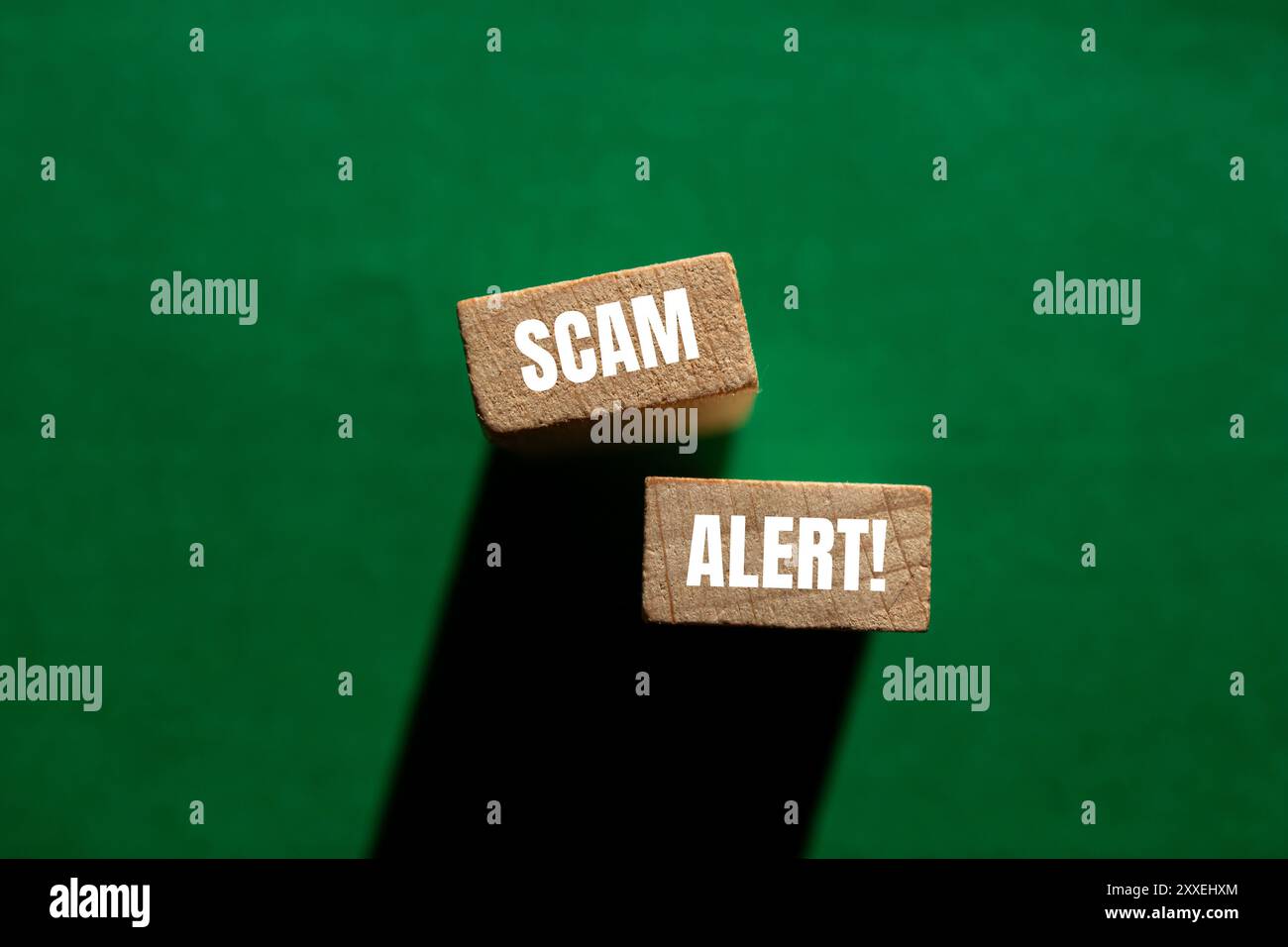Scam alert message written on wooden blocks on green background ...