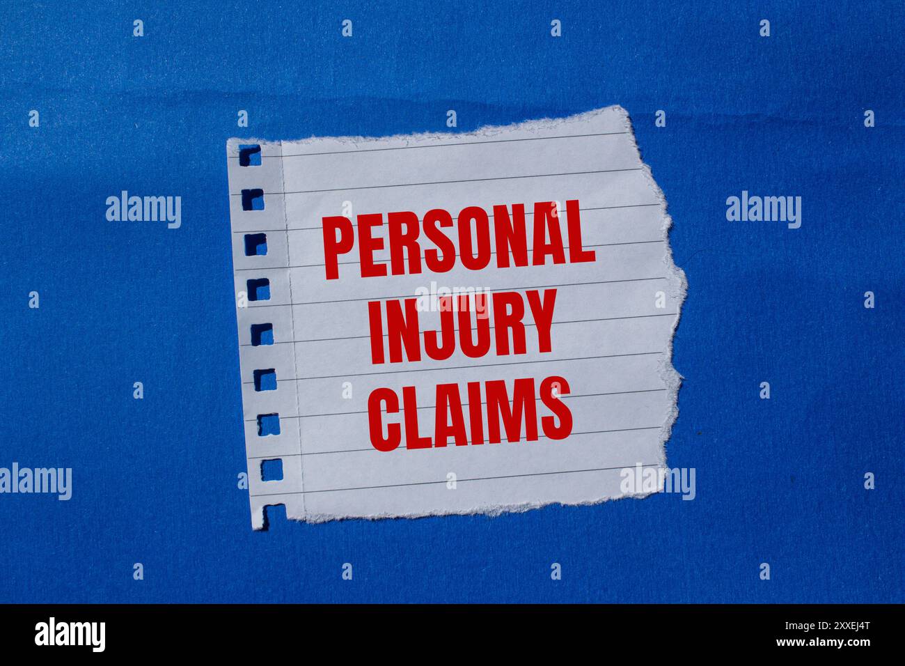 Personal injury claims message written on ripped torn paper piece with ...