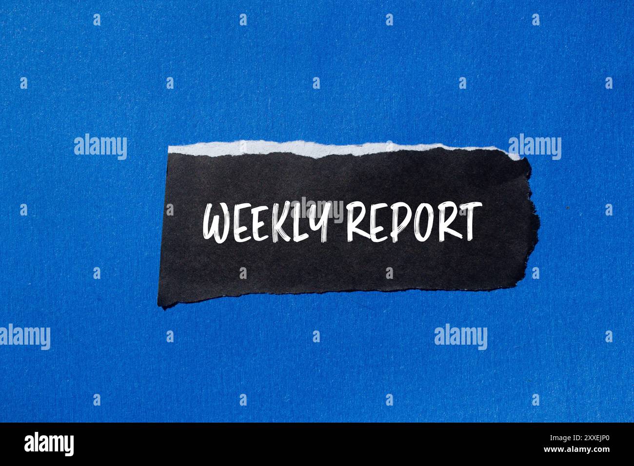 Weekly report message written on ripped torn black paper piece with ...