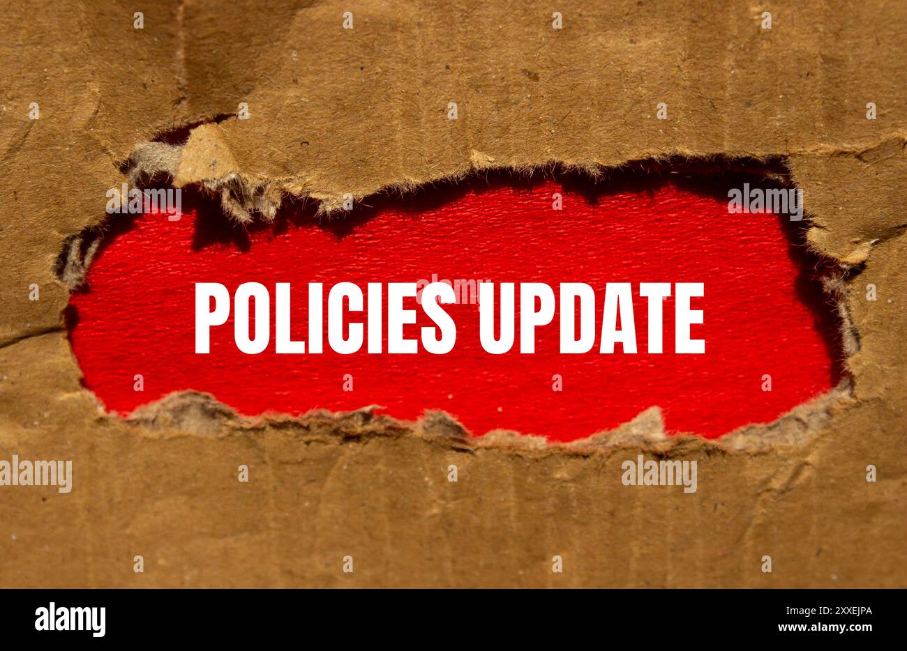 Policies update message written on torn cardboard paper with red background. Conceptual policies ...