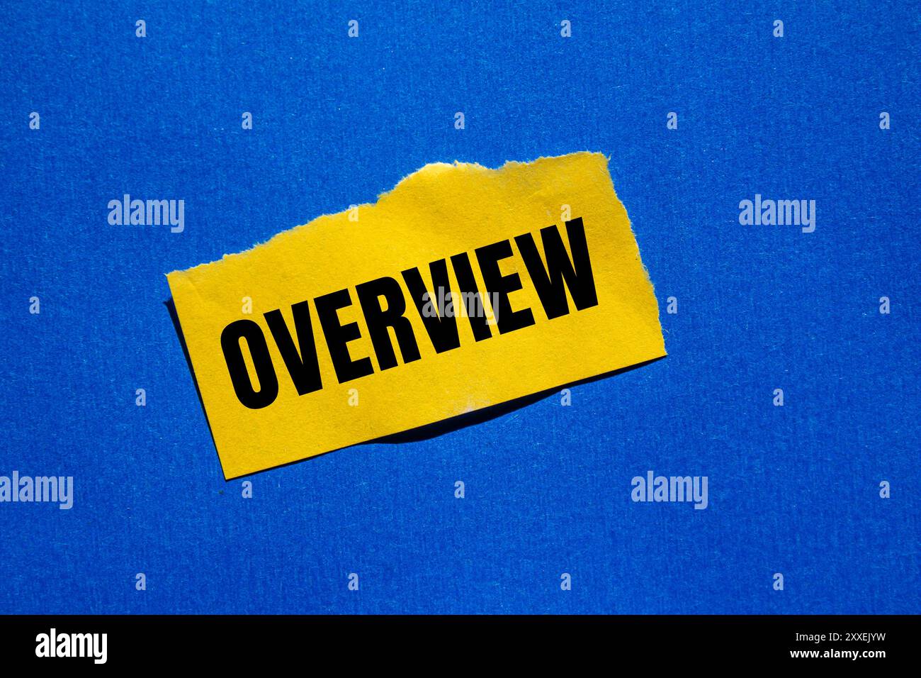 Overview message written on ripped torn yellow paper piece with ...