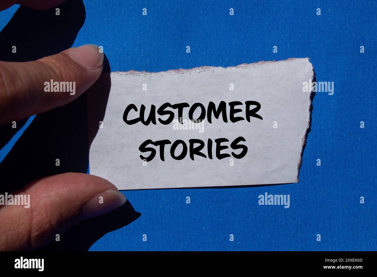 Customer stories message written on ripped torn paper with blue ...