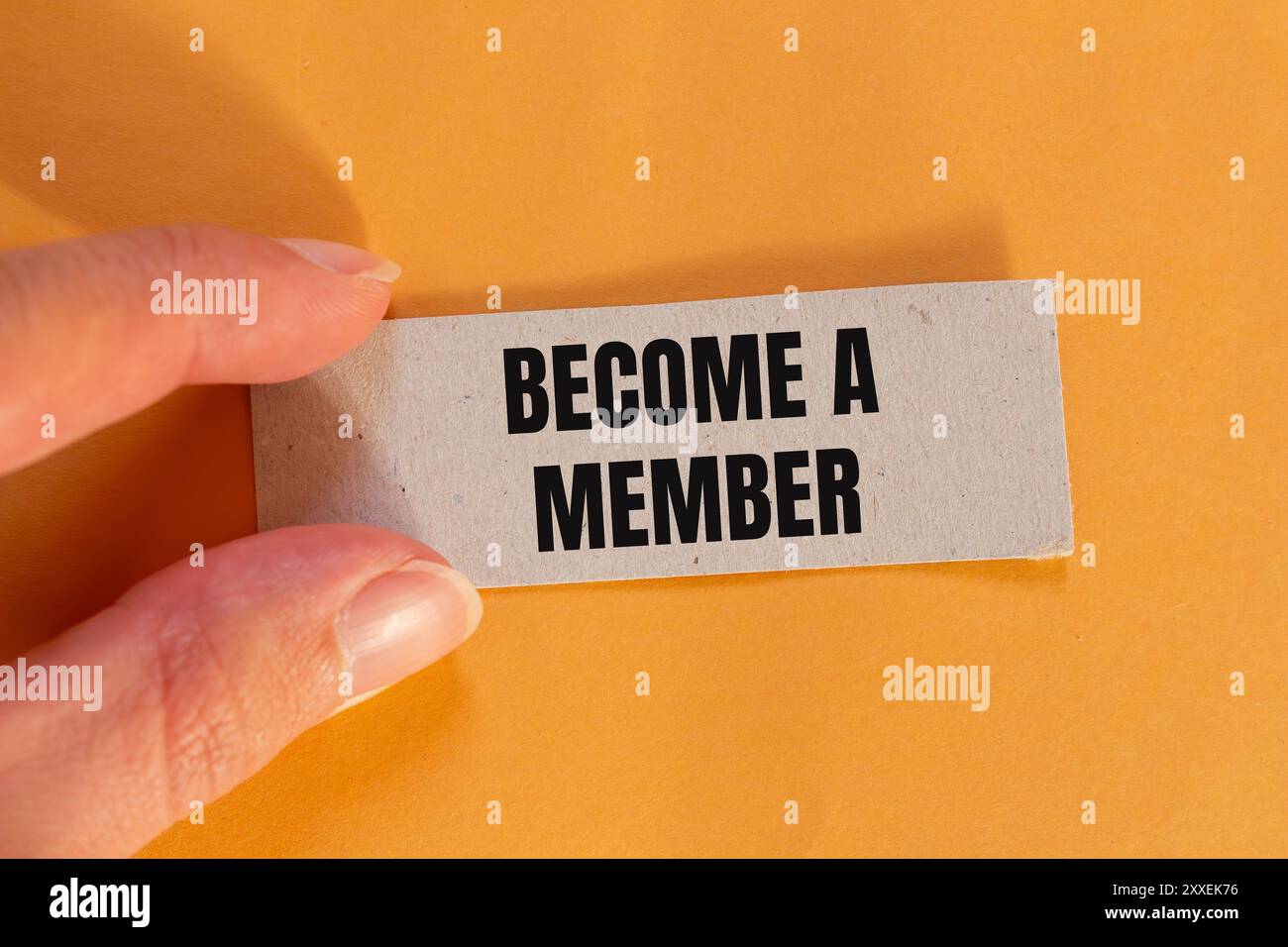 Become a member message written on ripped paper piece with orange ...