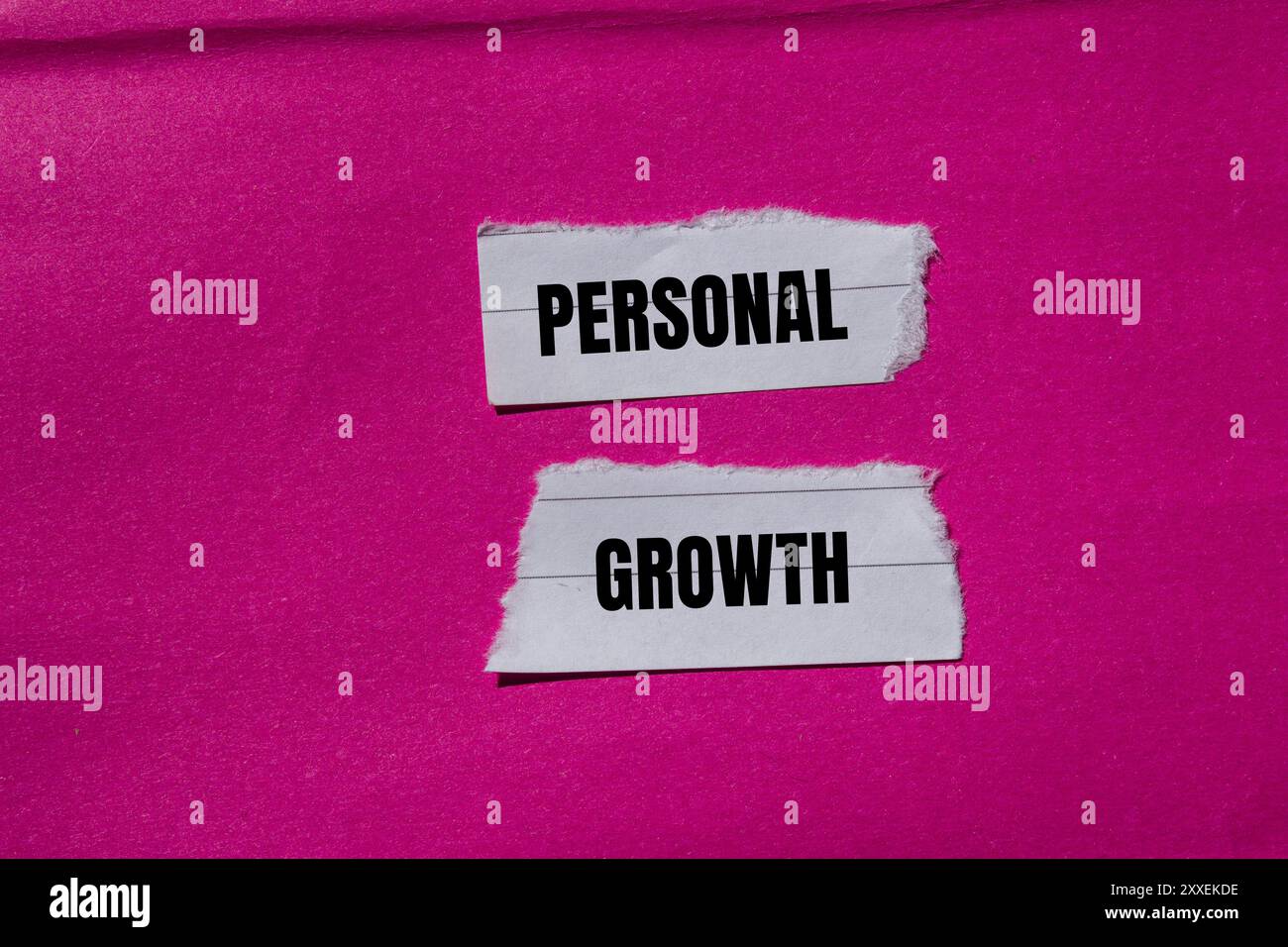 Personal growth message written on ripped torn paper pieces with pink ...