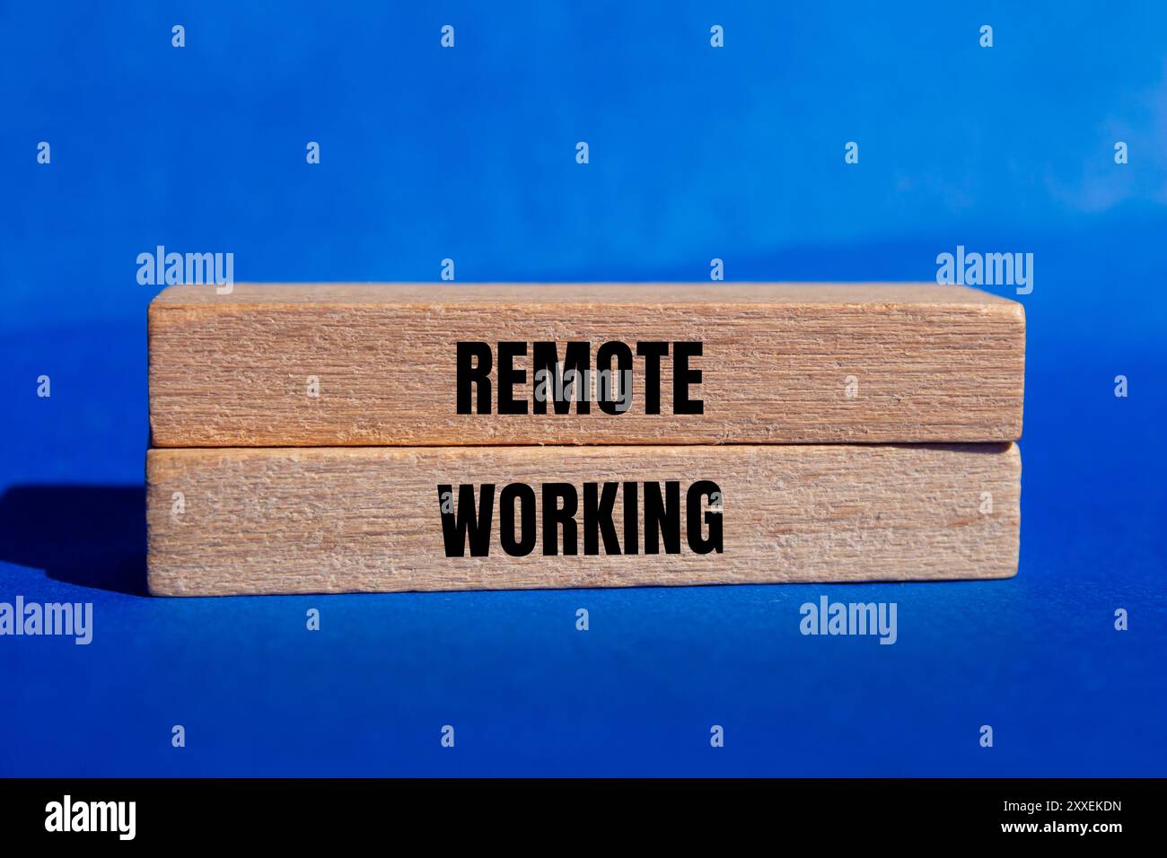Remote working message written on wooden blocks with blue background ...