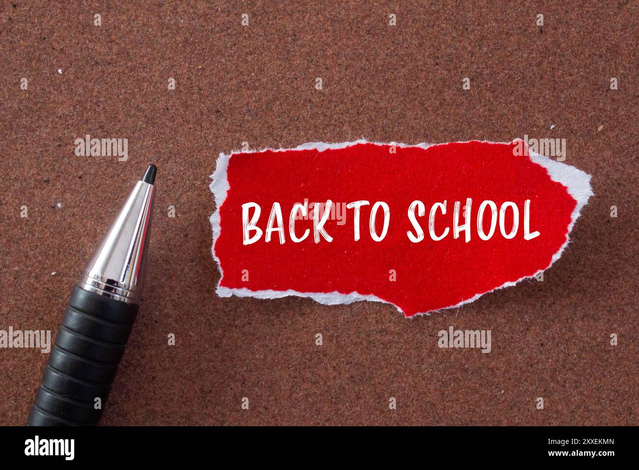 Back to school message written on ripped torn red paper and a pen with ...