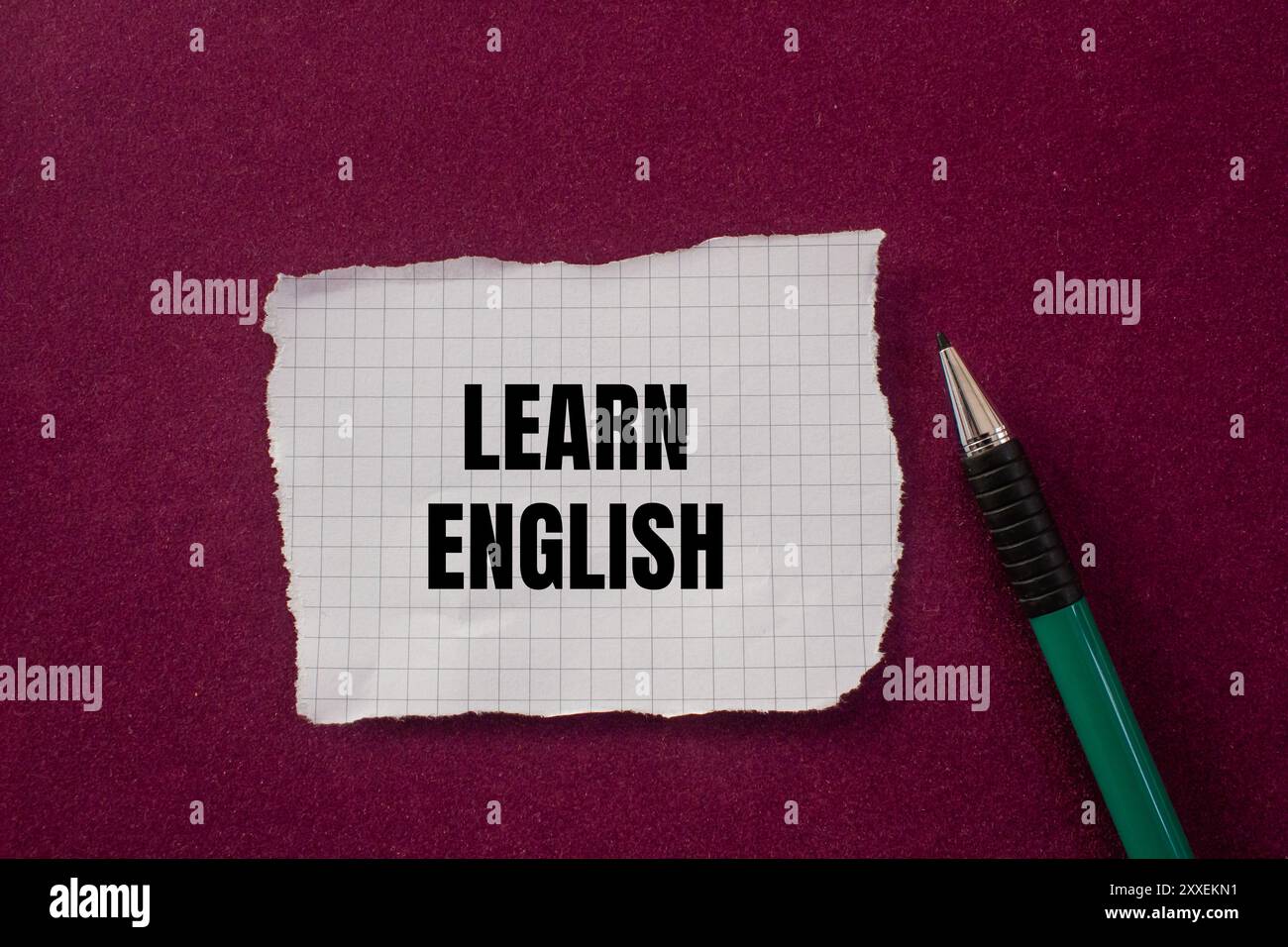 Learn english message written on ripped torn paper with a pen on purple background. Conceptual ...
