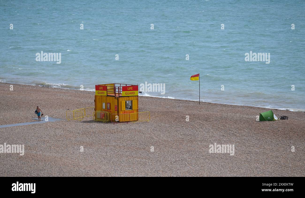 A single container lifeguard station and warning flag on a quiet stone ...