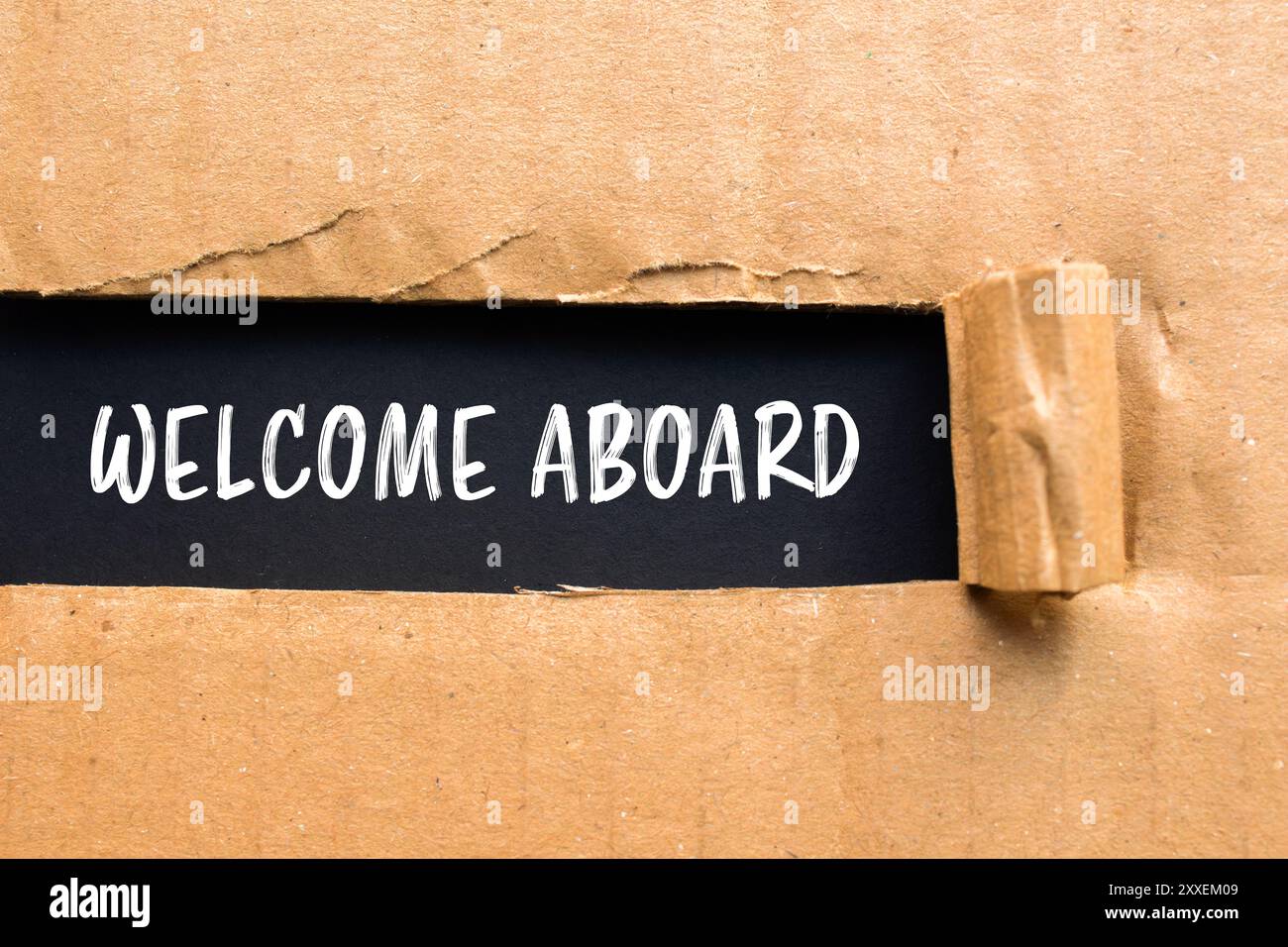 Welcome aboard message written on ripped torn cardboard paper with black background. Conceptual ...