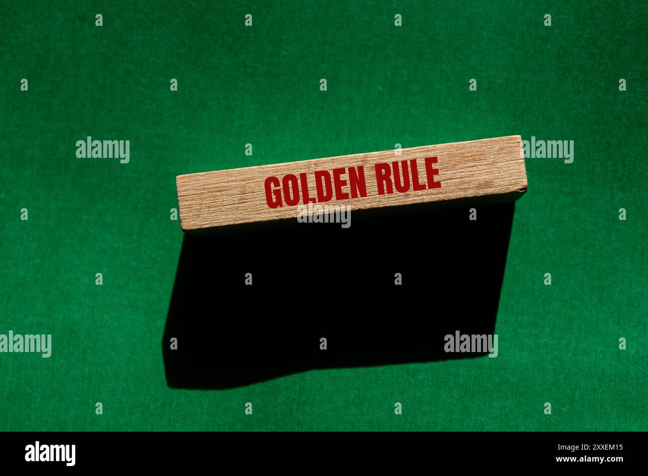 Golden rule message written on wooden block with green background ...