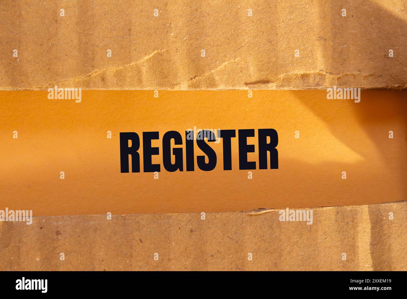 Register message written on ripped torn cardboard paper with orange background. Conceptual ...