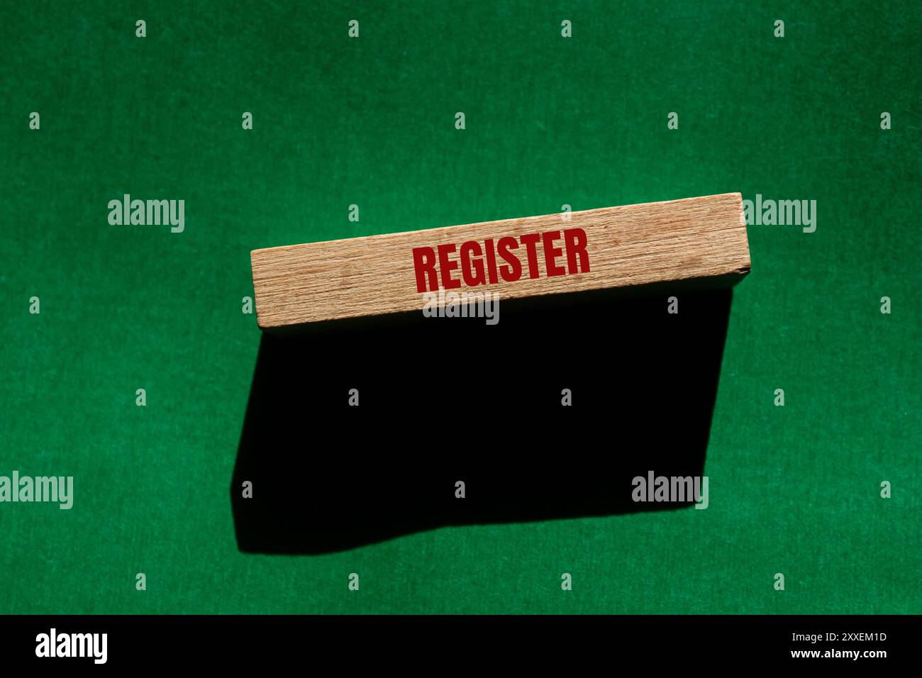 Register message written on wooden block with green background ...