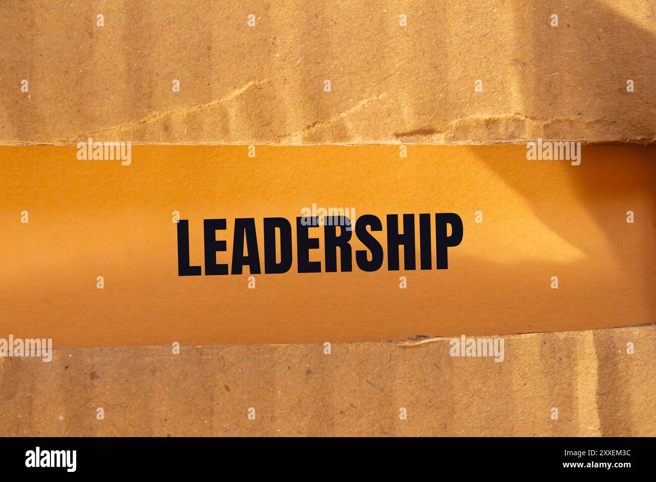 Leadership message written on ripped torn cardboard paper with orange ...