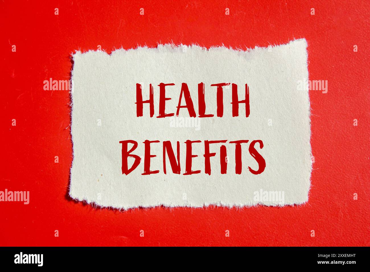 Health benefits message written on ripped torn paper piece with red background. Conceptual ...