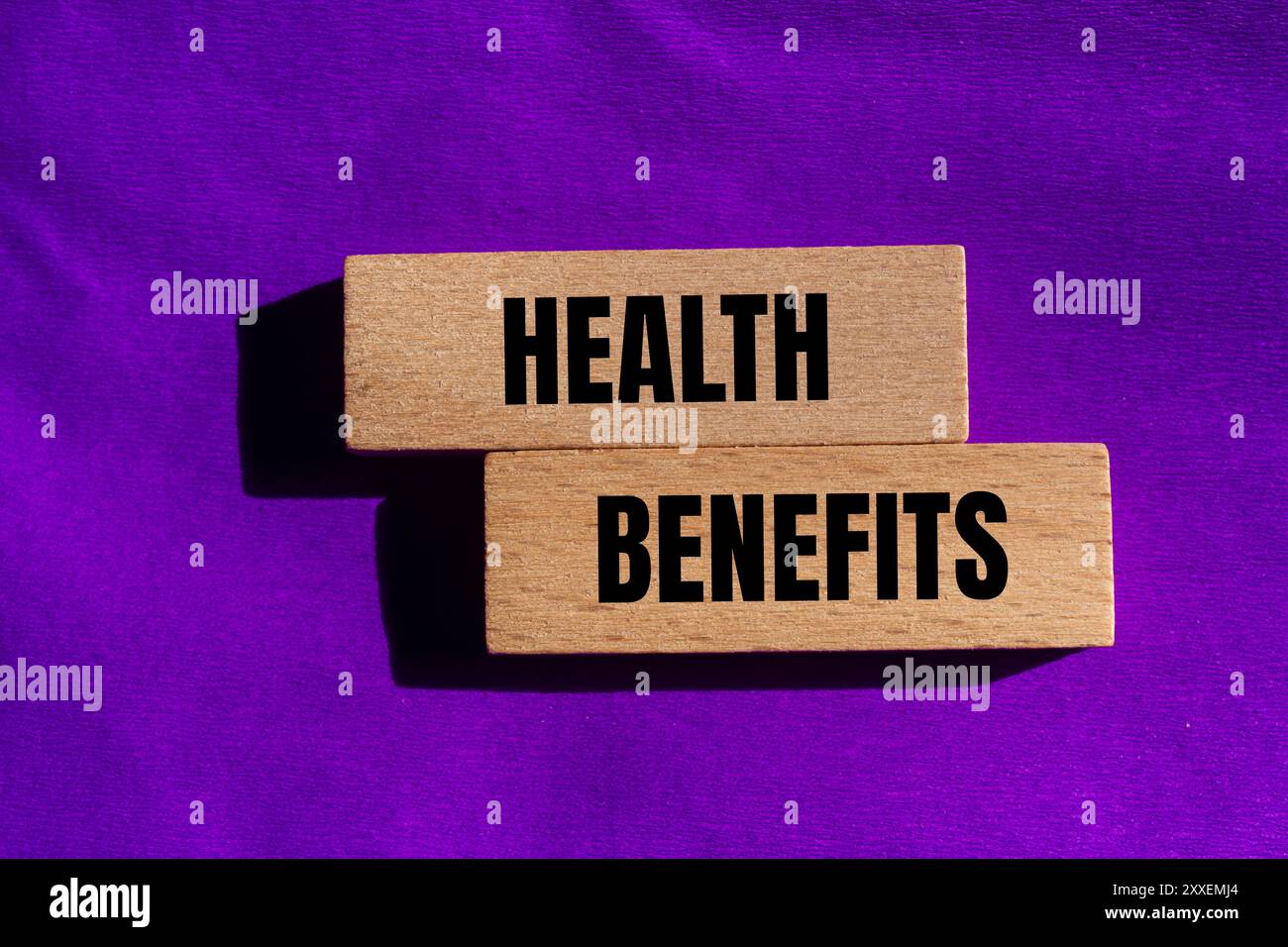 Health benefits message written on wooden blocks with purple background ...