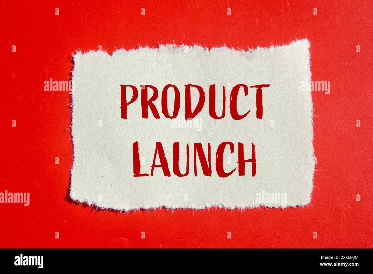 Product launch message written on ripped torn paper piece with red ...