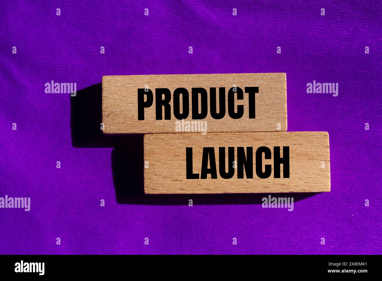 Product launch message written on wooden blocks with purple background ...