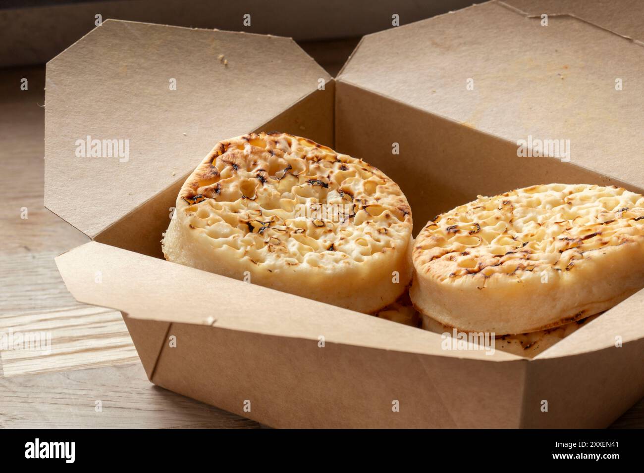 Crumpets in a cardboard tray, fresh from a bakery. Biodegradable ...