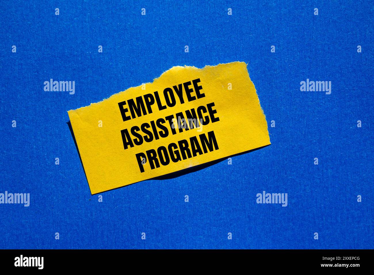 Employee assistance program message written on ripped torn yellow paper piece with ...