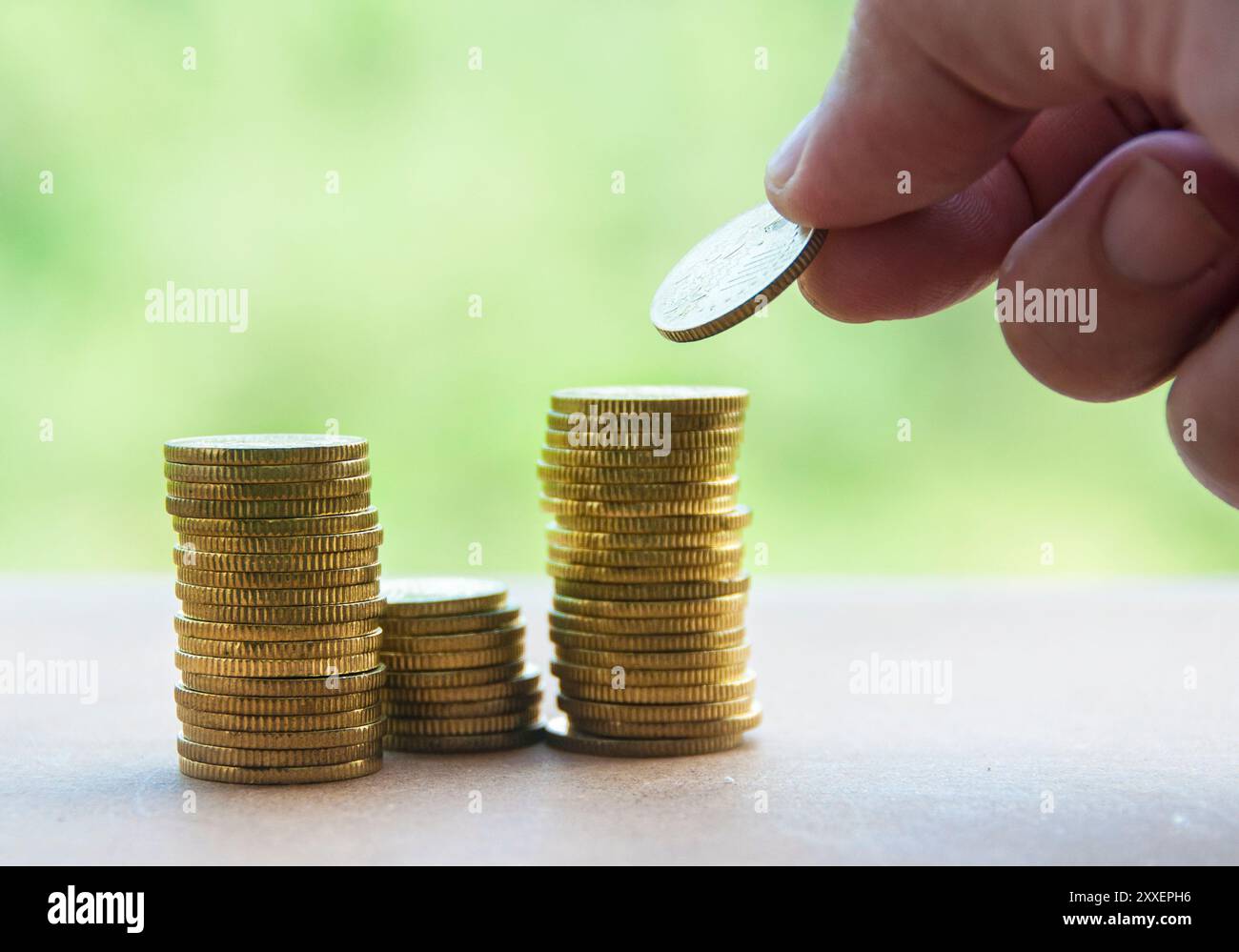 Hand putting golden coin on a stacking coins. Wealth and copy space ...
