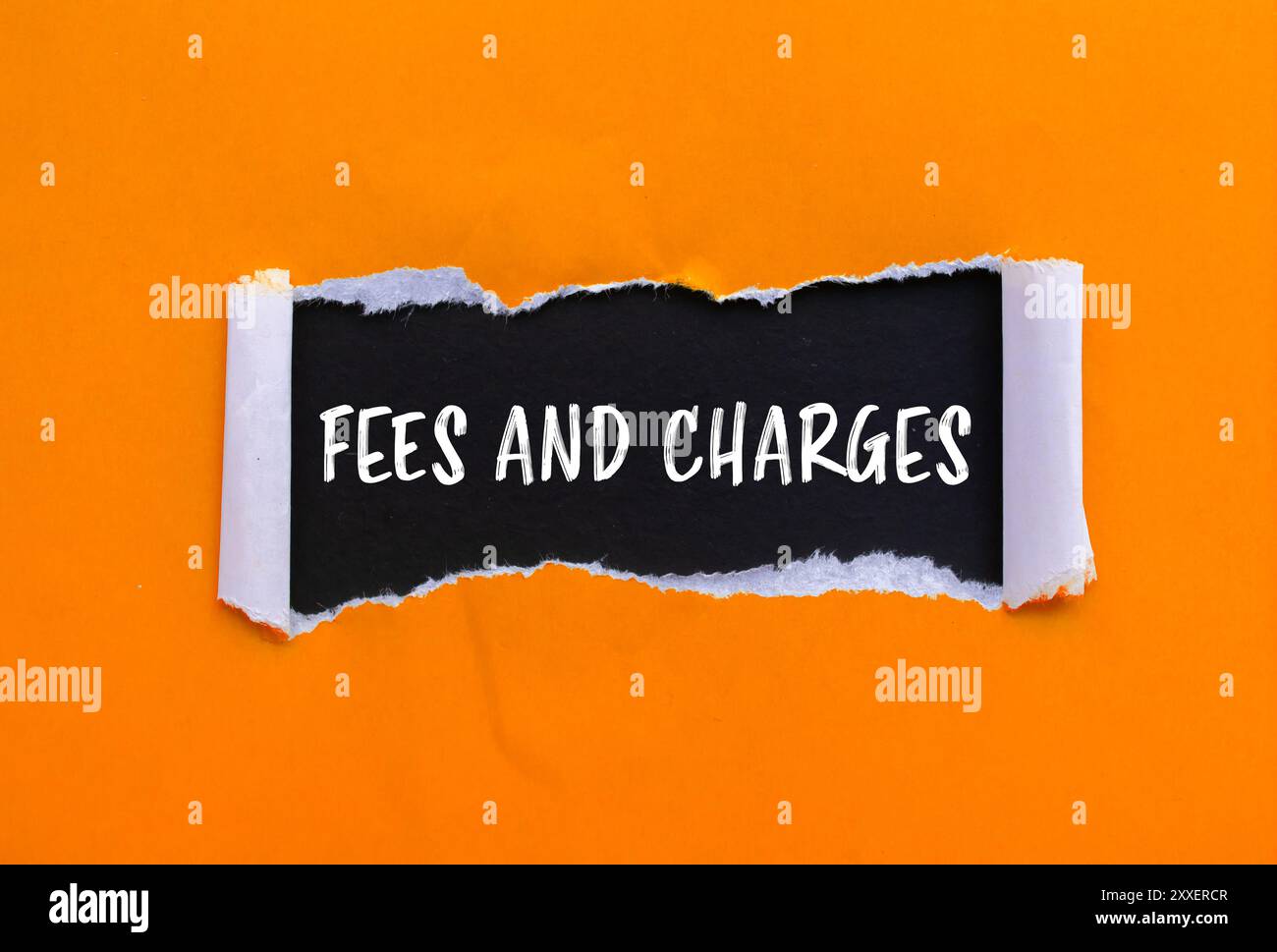 Fees and charges message written on ripped torn orange paper with black ...
