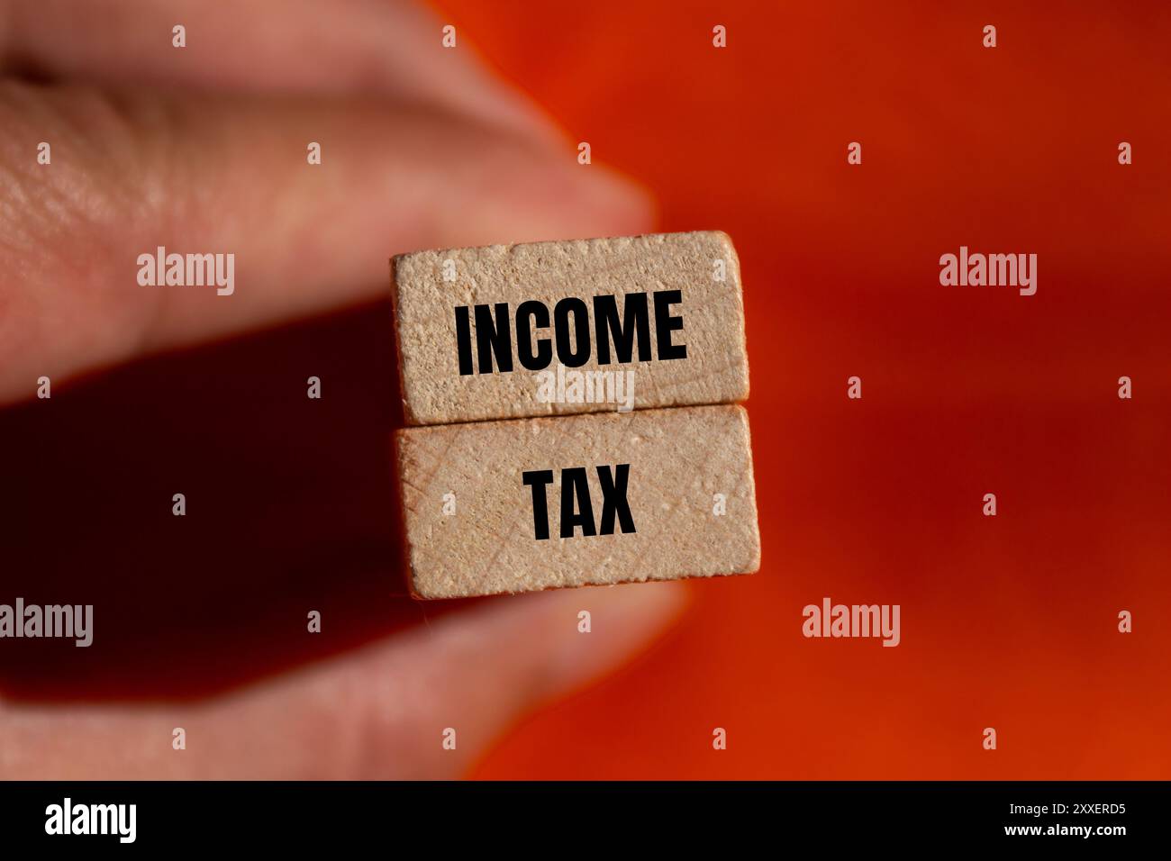 Income tax message written on wooden blocks with orange background ...