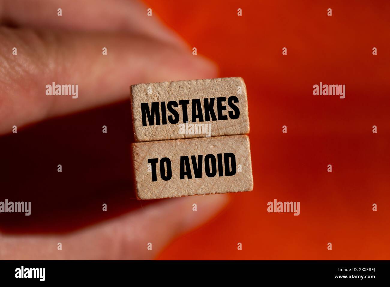 Mistakes to avoid message written on wooden blocks with orange ...