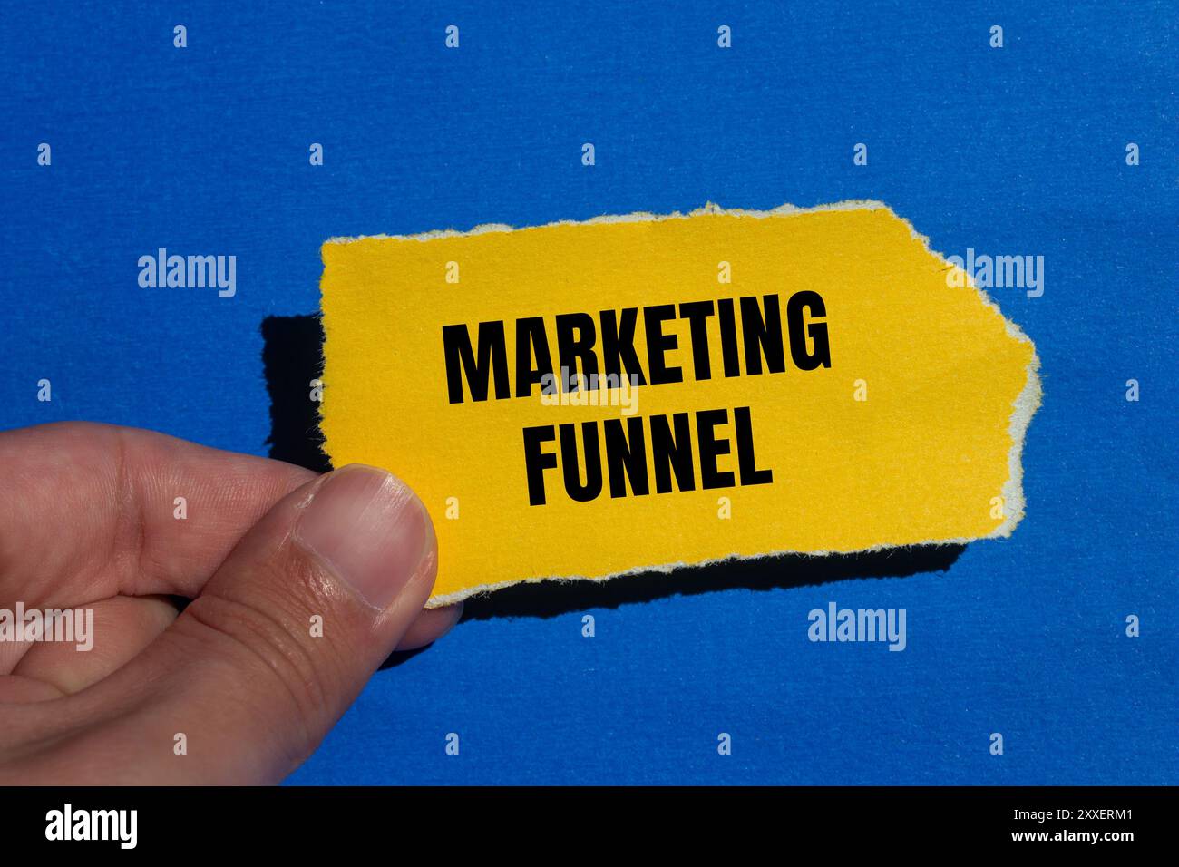 Marketing funnel message written on ripped torn yellow paper with blue ...