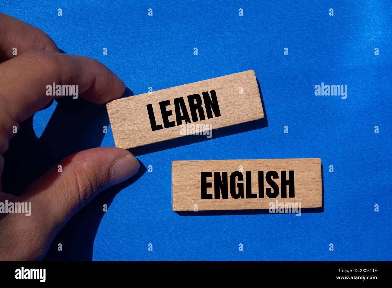 Learn english message written on wooden blocks with blue background ...